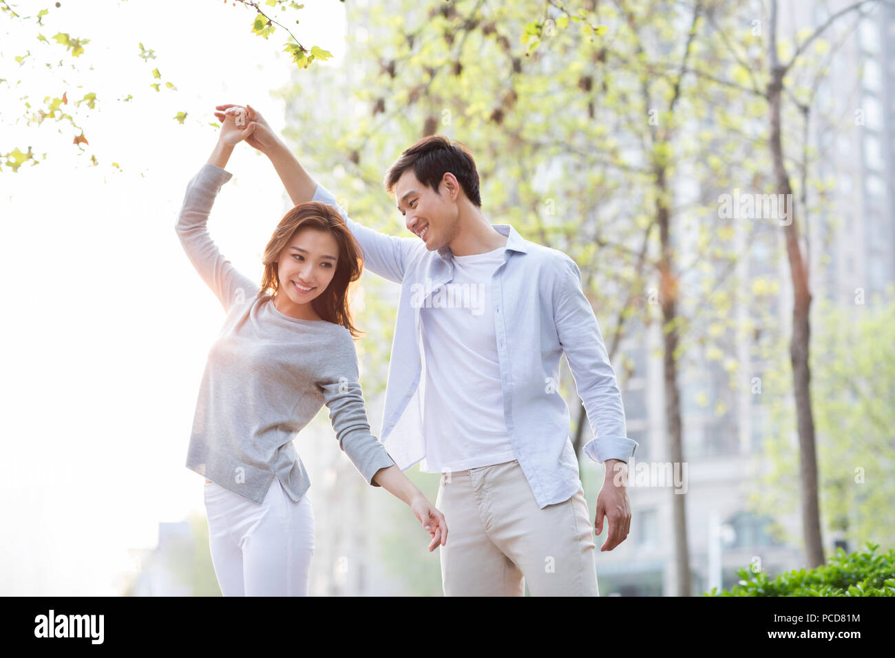 Happy young Chinese couple dancing outdoors Stock Photo - Alamy