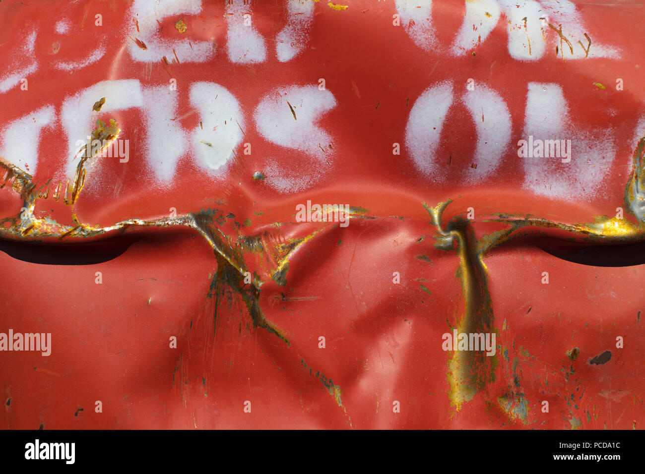 Close up of dented and rusty old red metal oil drum with white ...