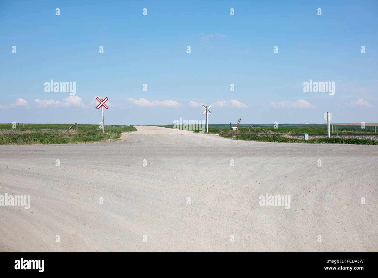 Railroad crossing along rural road and farmland Stock Photo - Alamy