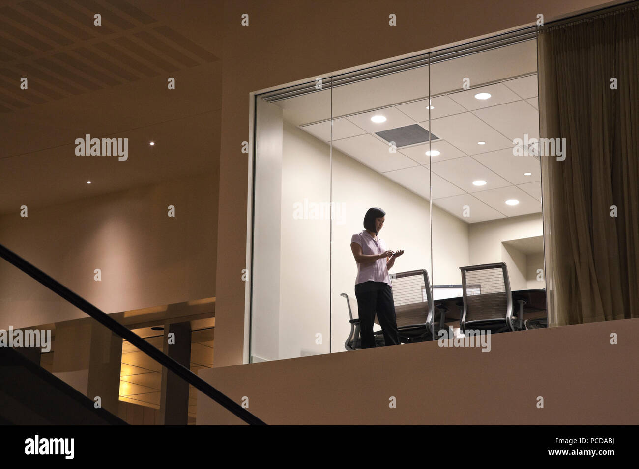 A view looking into a converence room at night with two business people ...