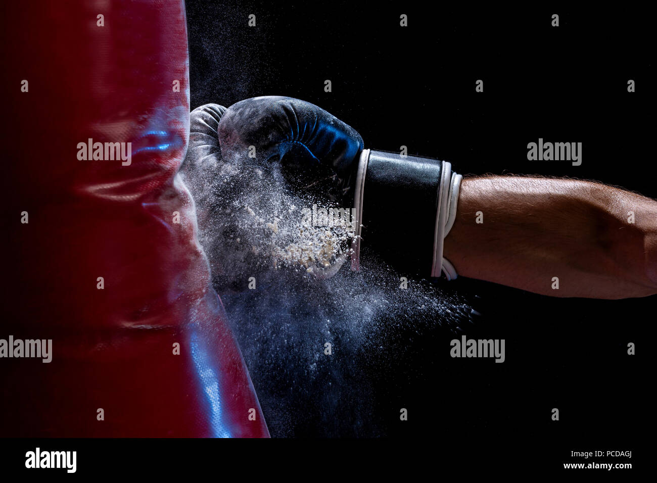 Close-up hand of boxer at the moment of impact on punching bag over ...