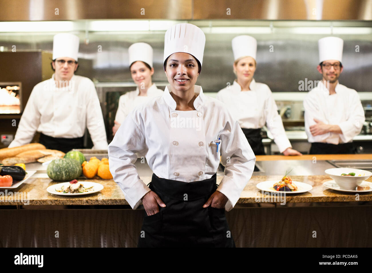 A portrait of a black female chef and her team of chefs in the ...