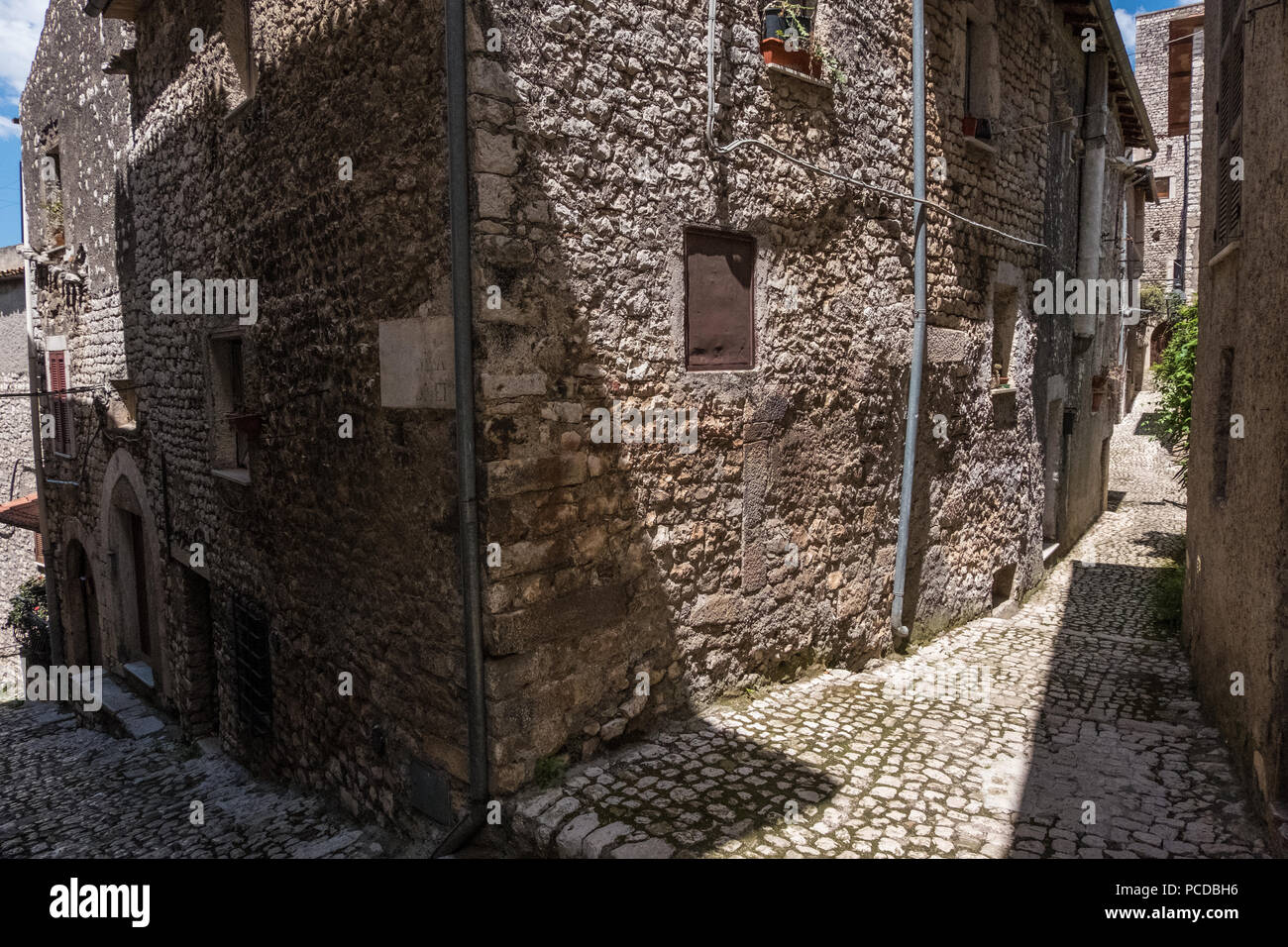 View of an alley with houses of the ancient stone made medieval town of ...