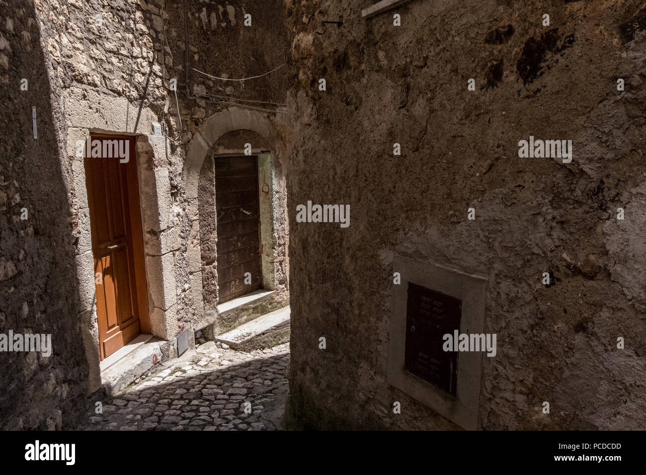 View of an alley with houses of the ancient stone made medieval town of ...