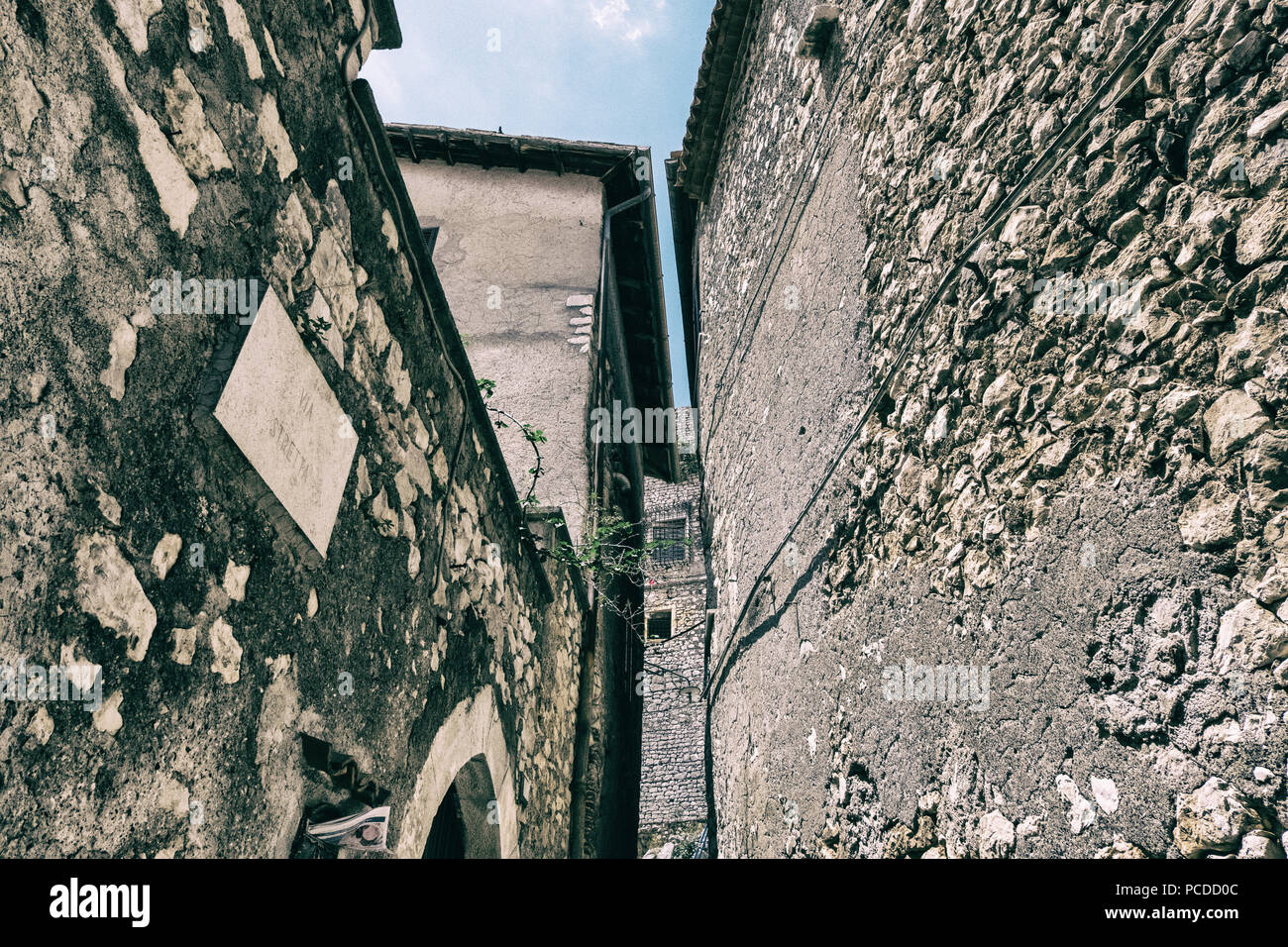 View of an alley with houses of the ancient stone made medieval town of ...
