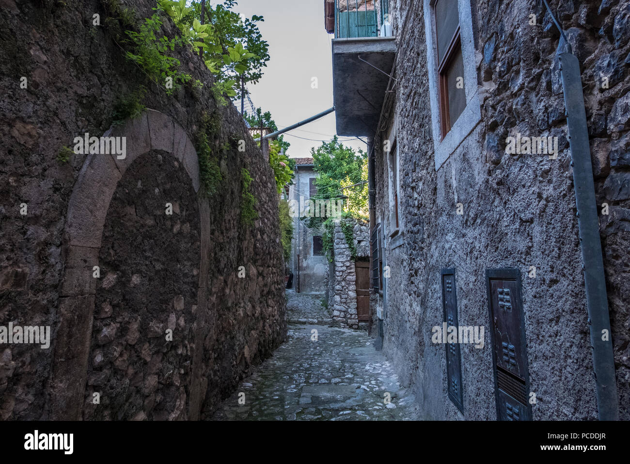 View of an alley with houses of the ancient stone made medieval town of ...