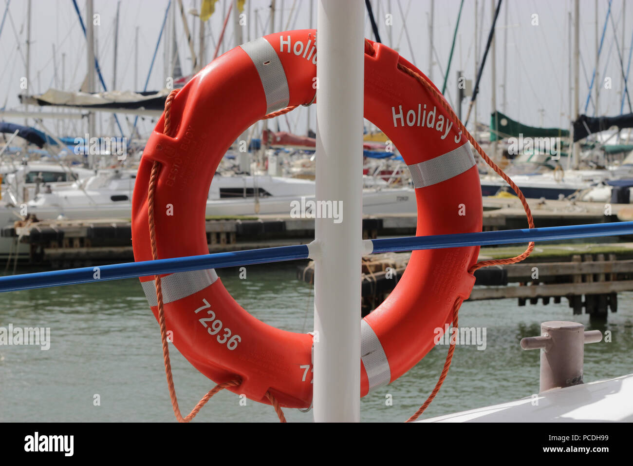 Red lifeguard buoy on pier of marina Stock Photo - Alamy