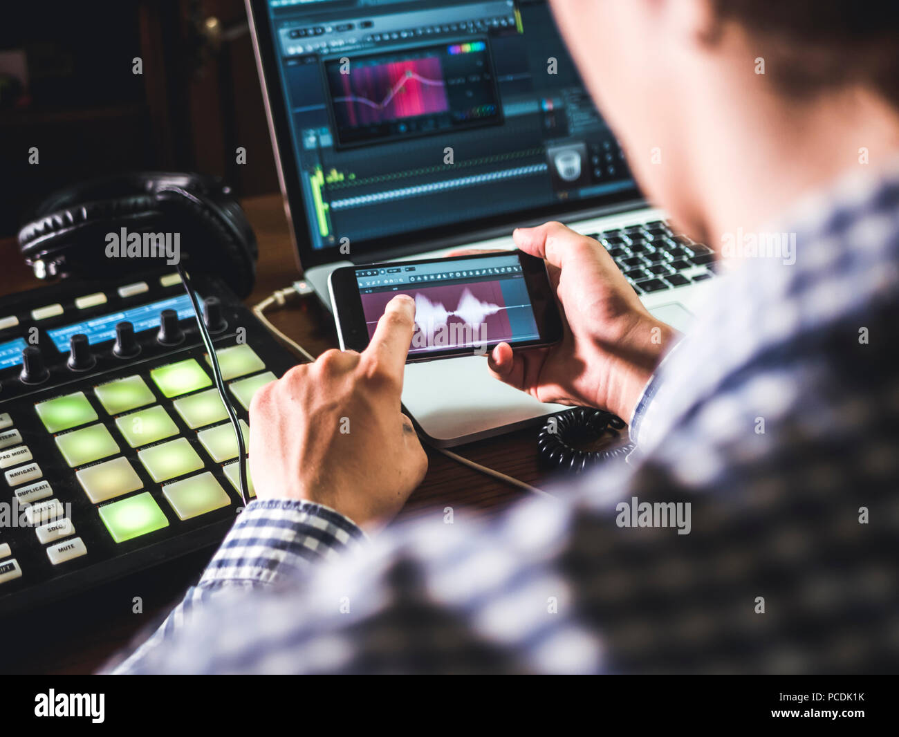 close up sound producer's hand holding phone and using app to create ...