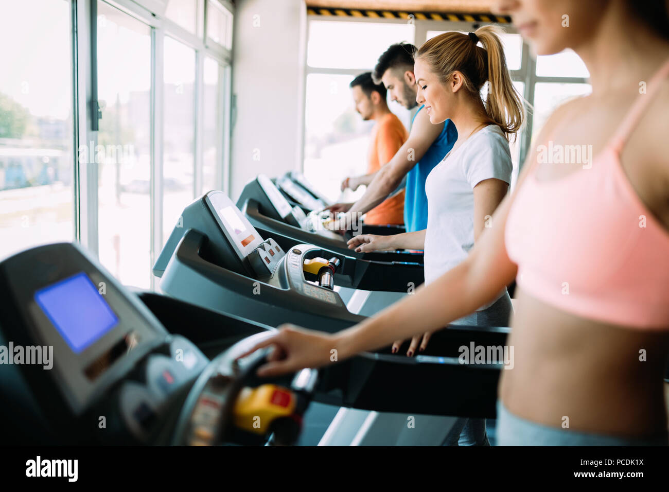 Happy people on treadmills in the gym Stock Photo - Alamy