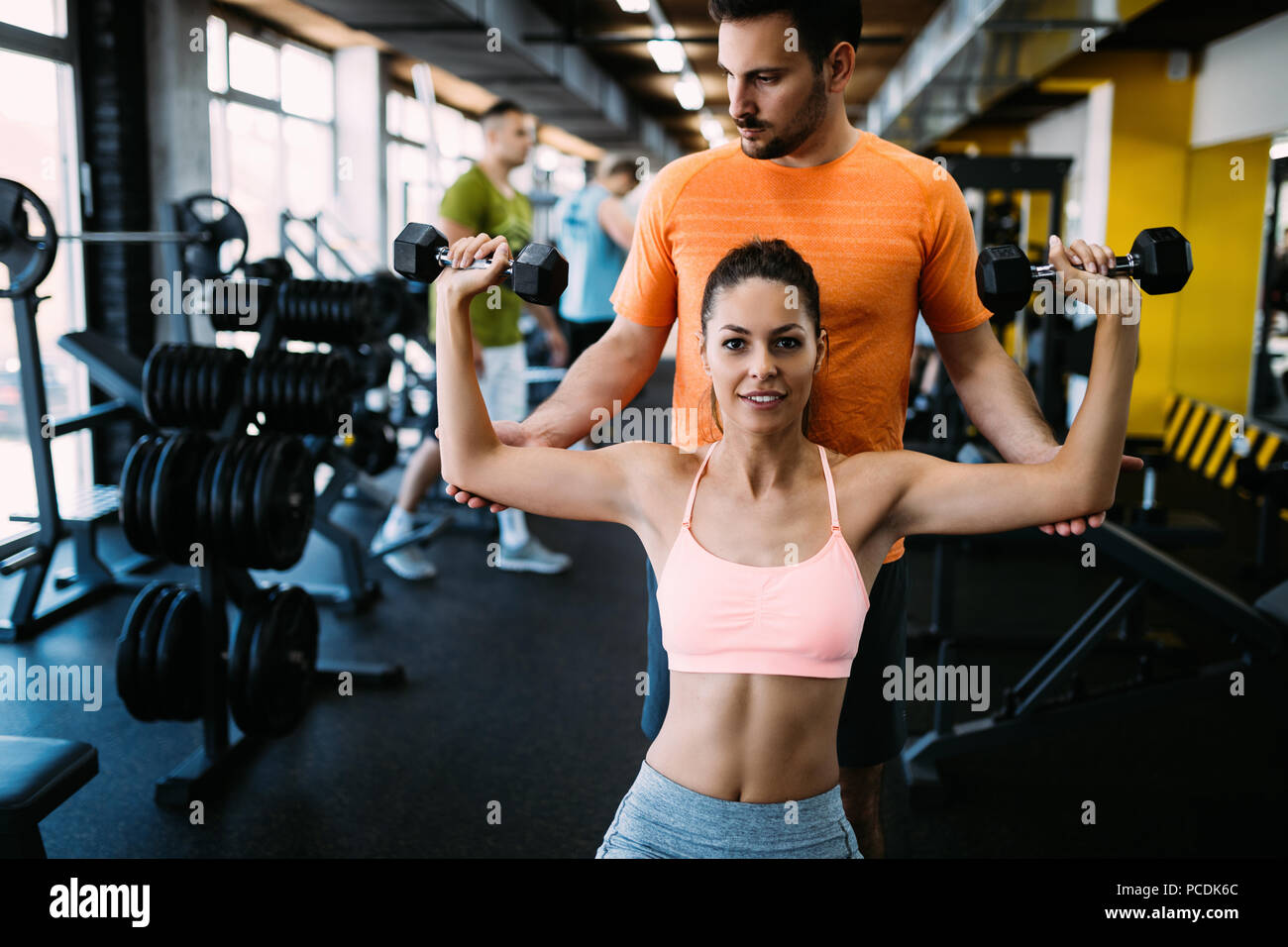 Personal trainer giving instructions in gym Stock Photo - Alamy