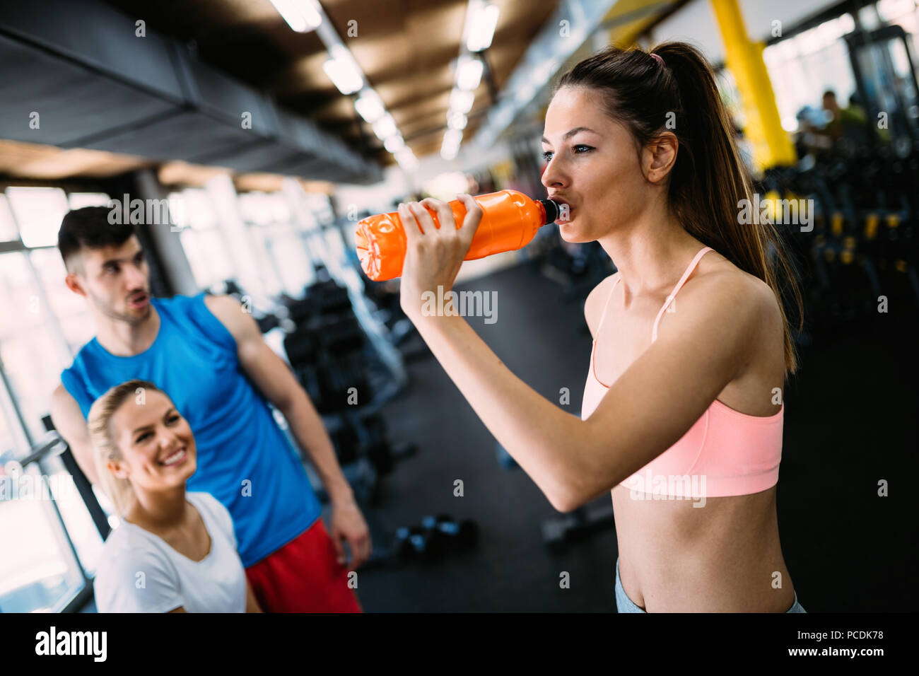 Young woman drinking water while exercising Stock Photo - Alamy