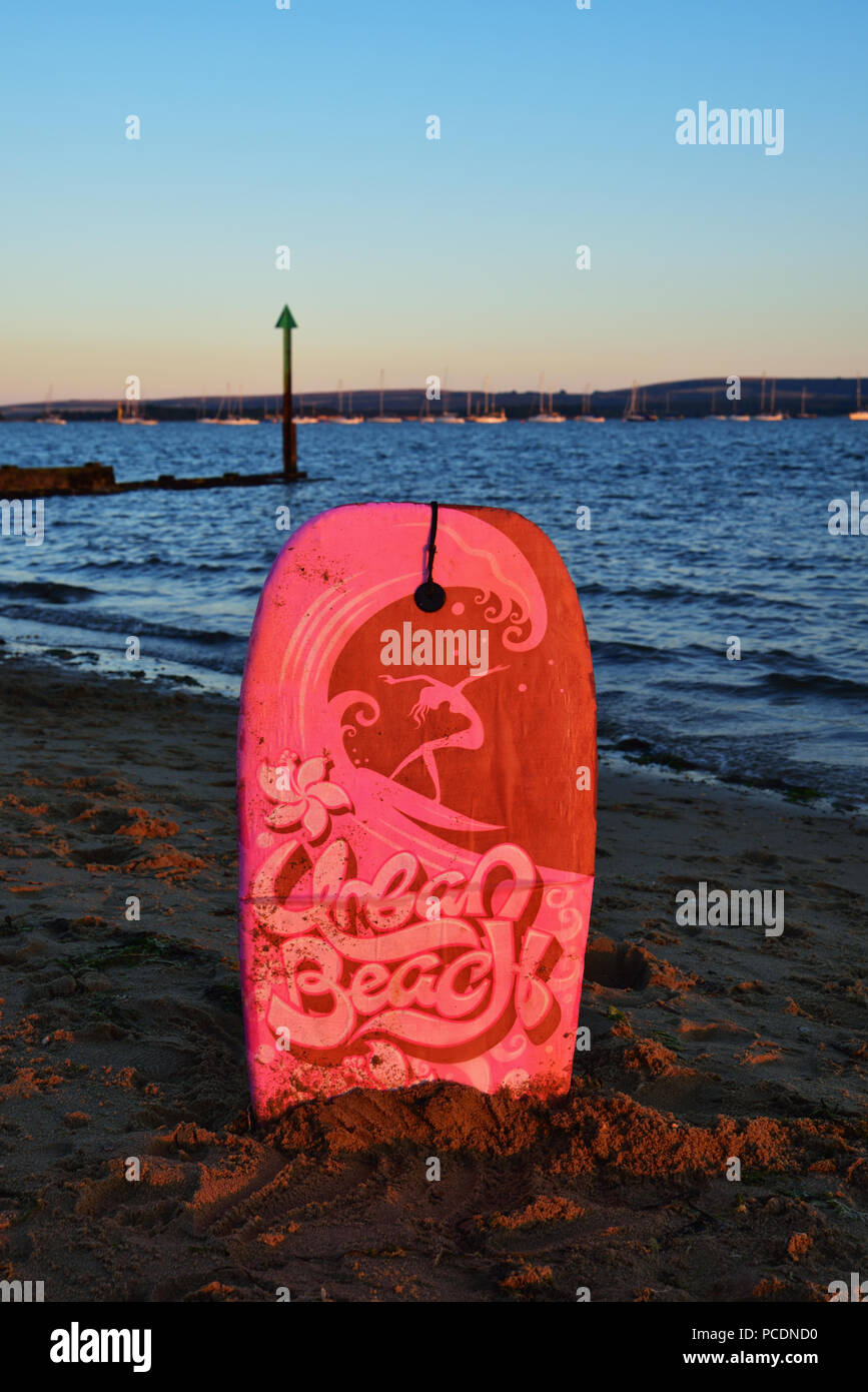 Abandoned child's body board stood on end on the beach Stock Photo - Alamy