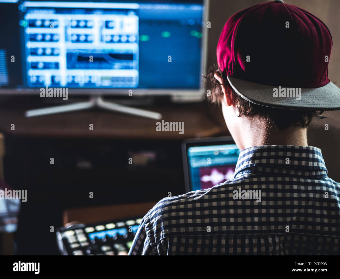 young male sound engineer working in professional music studio with ...