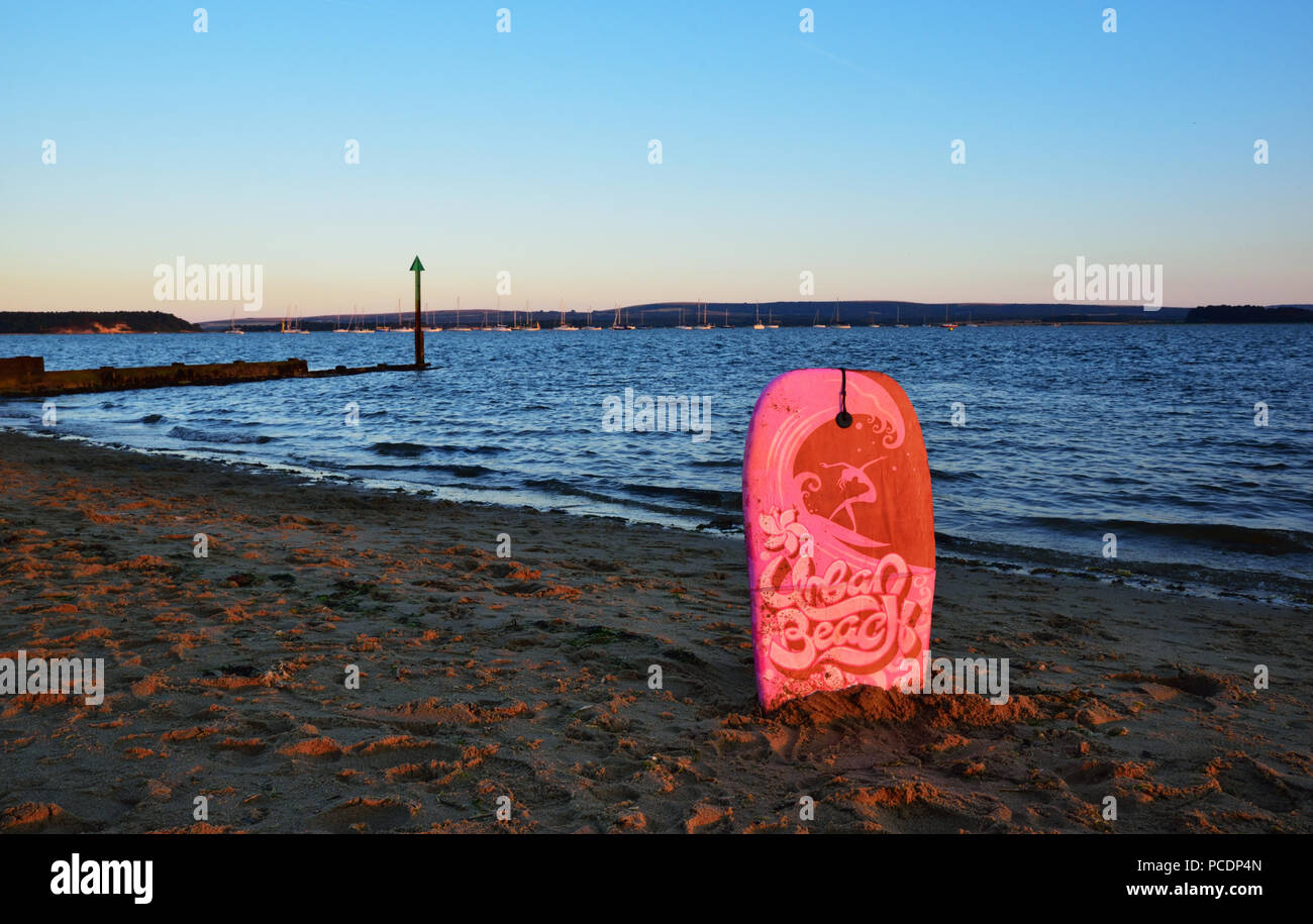 Abandoned child's body board stood on end on the beach Stock Photo - Alamy
