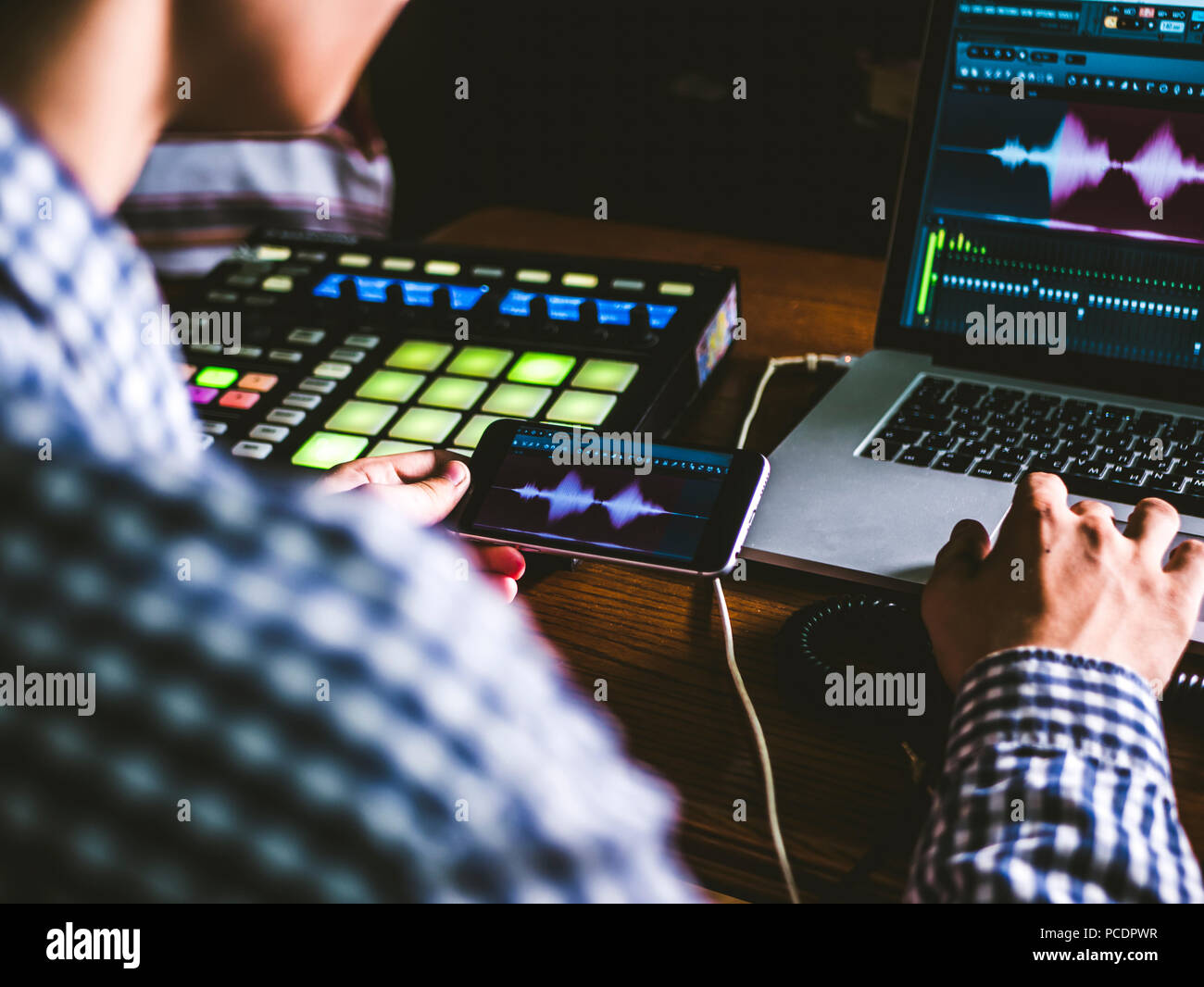 close up person creating music using phone and other sound equipment ...