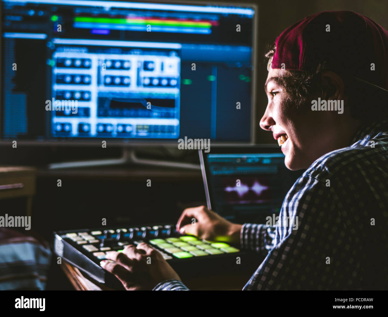 young smiling happy man in the sound recording studio working on the ...