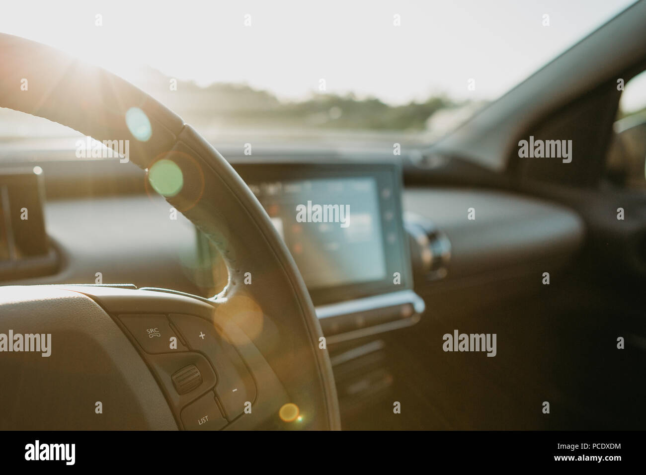 Conceptual picture of a road trip. Close-up steering wheel and view ...