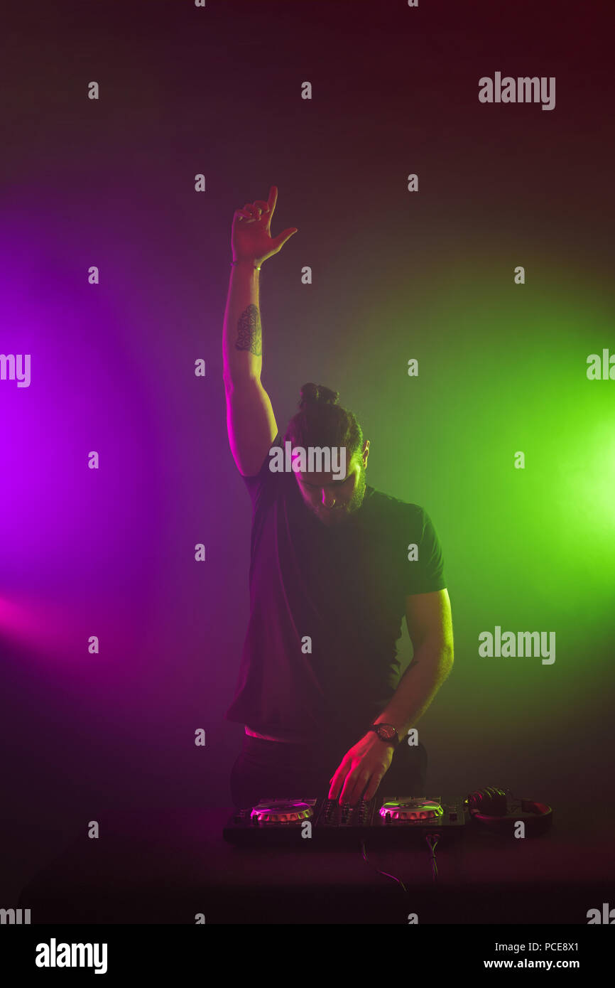 DJ at work mixing sound on her decks at a party or night club with ...