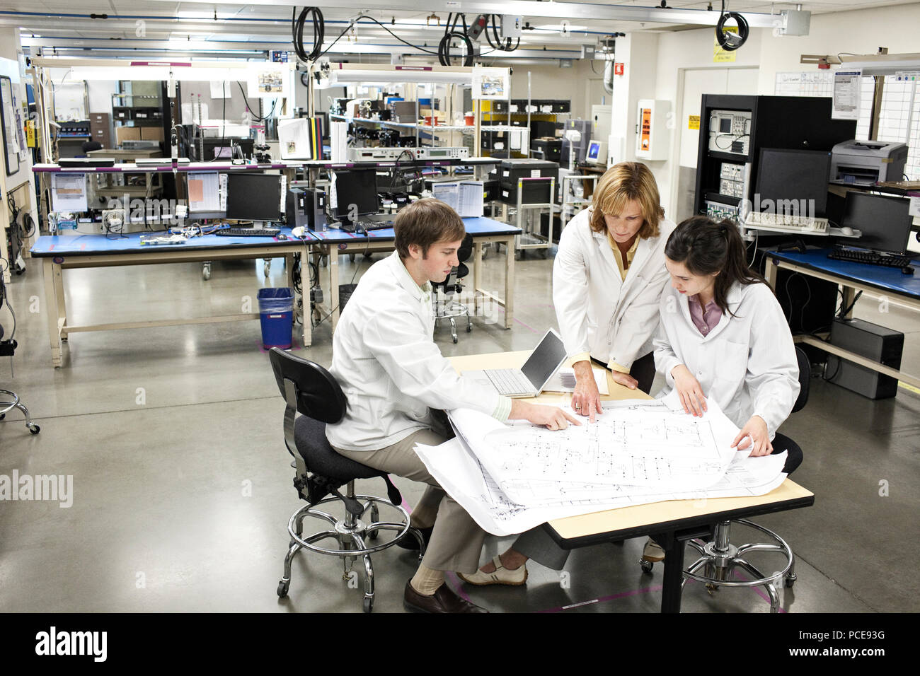 A team of technicians working over a problem in a technical research ...