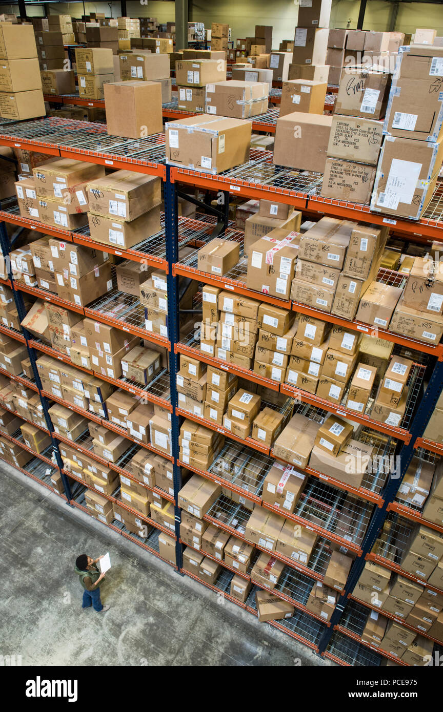 A view from above looking down on a warehouse worker checkig inventory ...