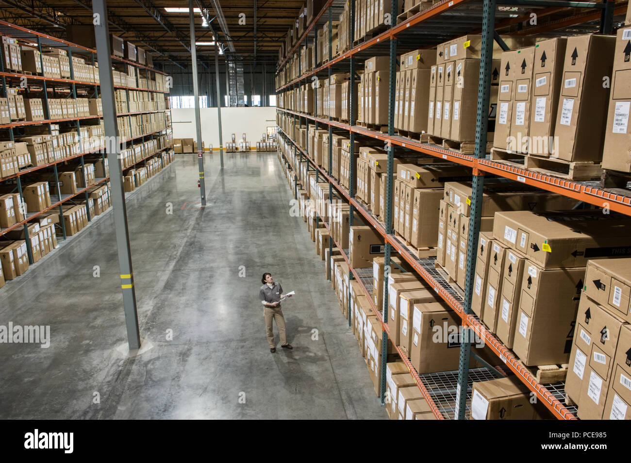 A view from above looking down on a warehouse worker checkig inventory ...