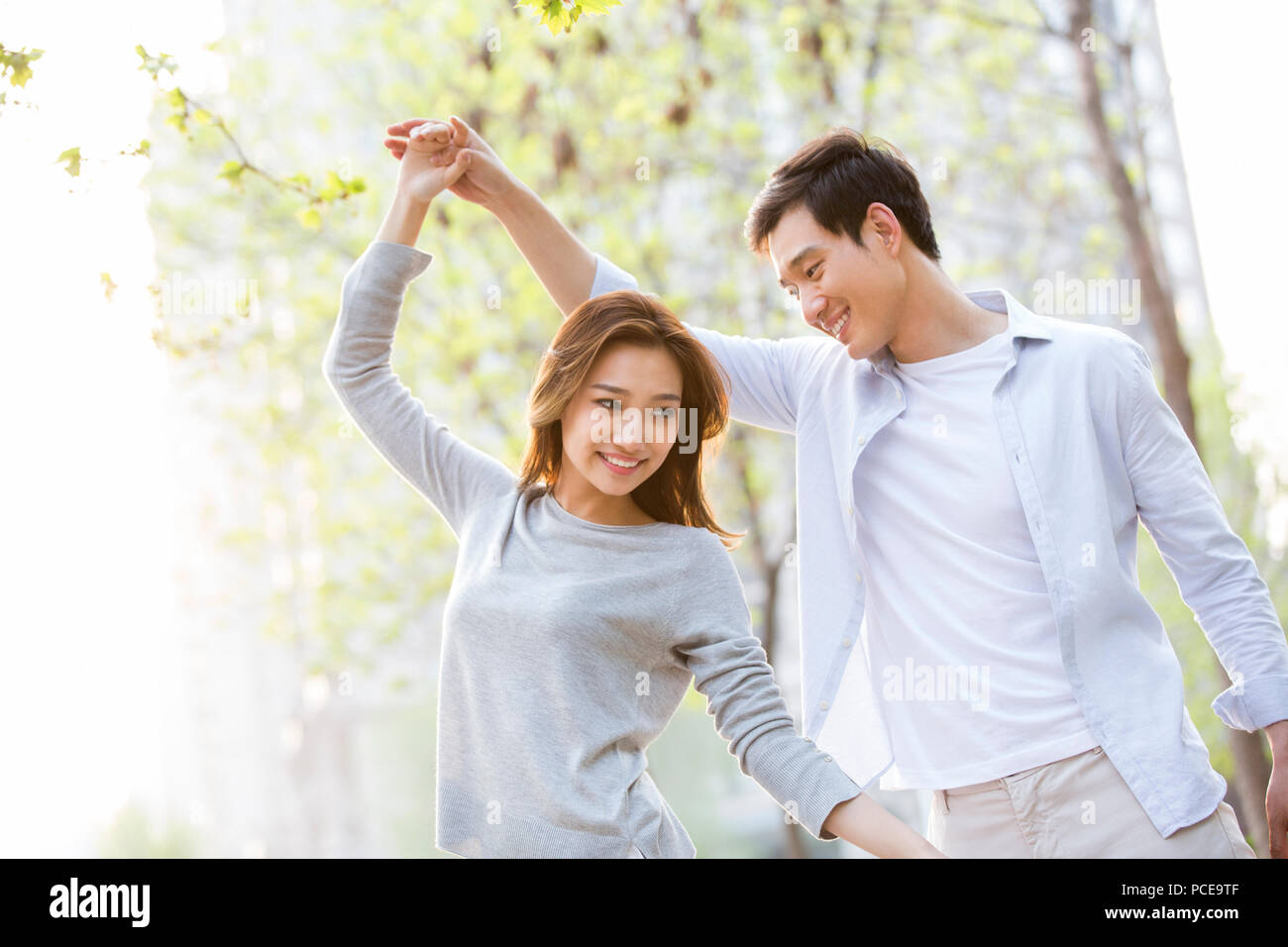 Happy young Chinese couple dancing outdoors Stock Photo - Alamy