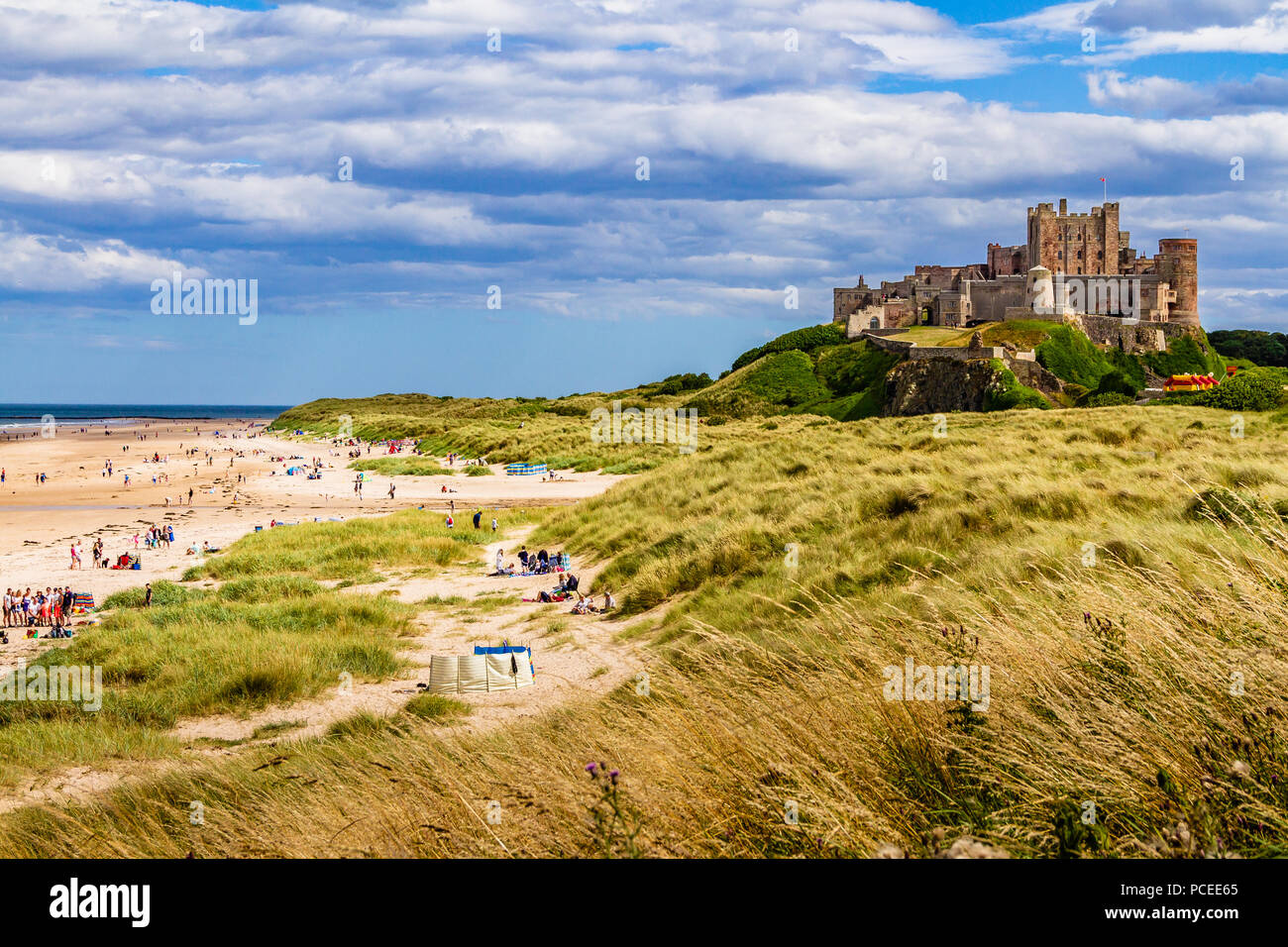 Bamburgh Castle and beach on a busy sunny summer's day, Bamburgh ...