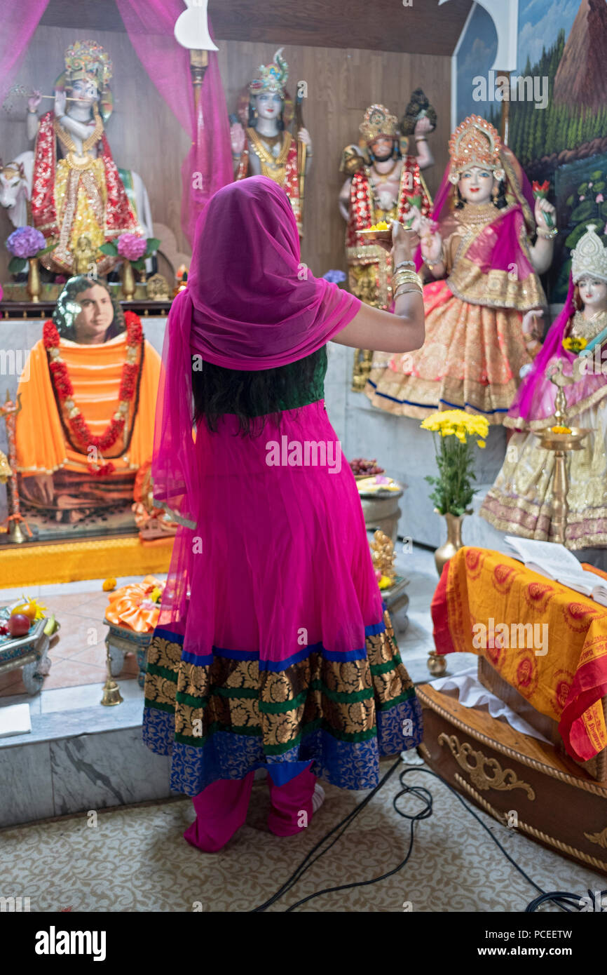 A teenage Hindu young lady offering flower petals to the Gods and ...