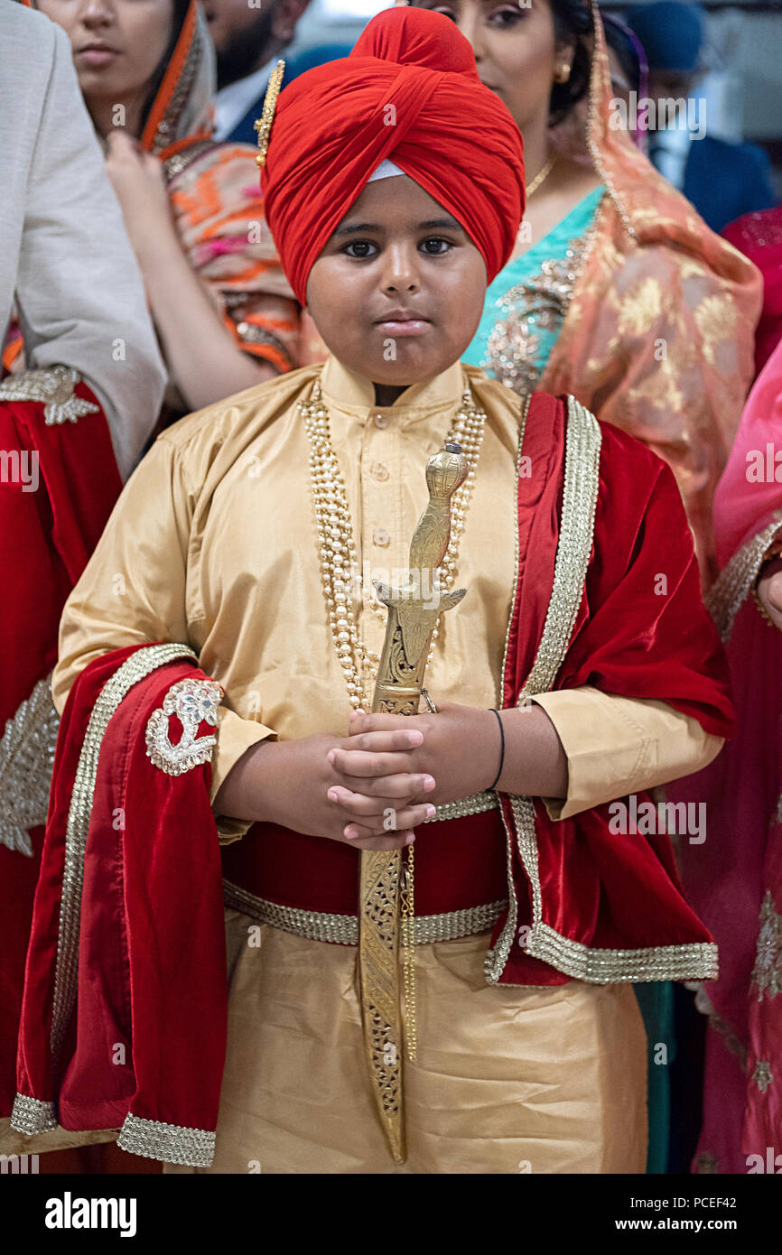 A Sikh teenager with a sword at his brother's wedding at a temple in ...