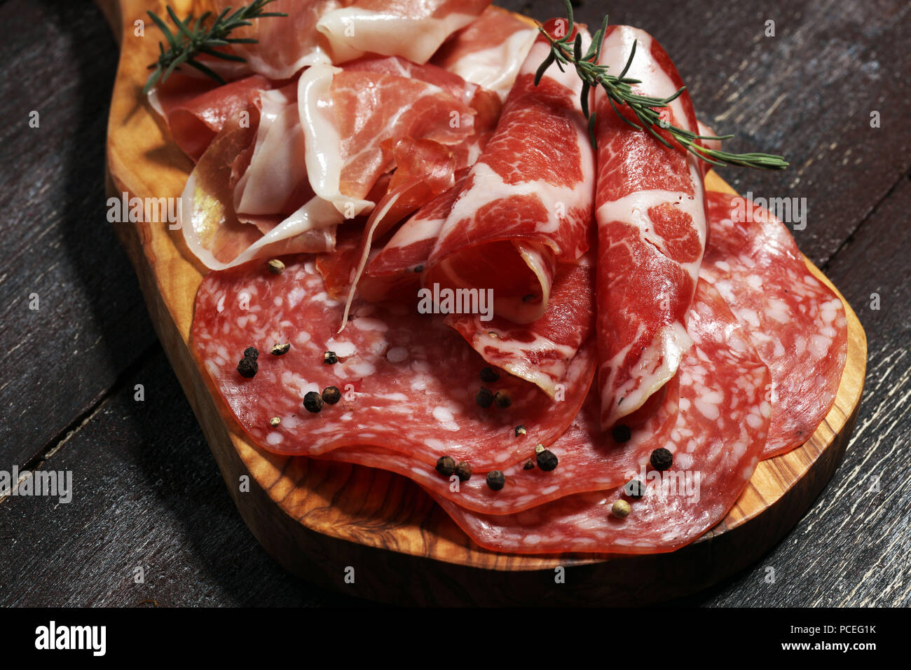 Food tray with delicious salami, coppa, fresh sausages and herbs. Meat ...