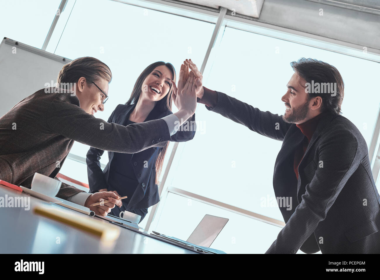 Businesspeople at office working together giving high five cheer Stock ...