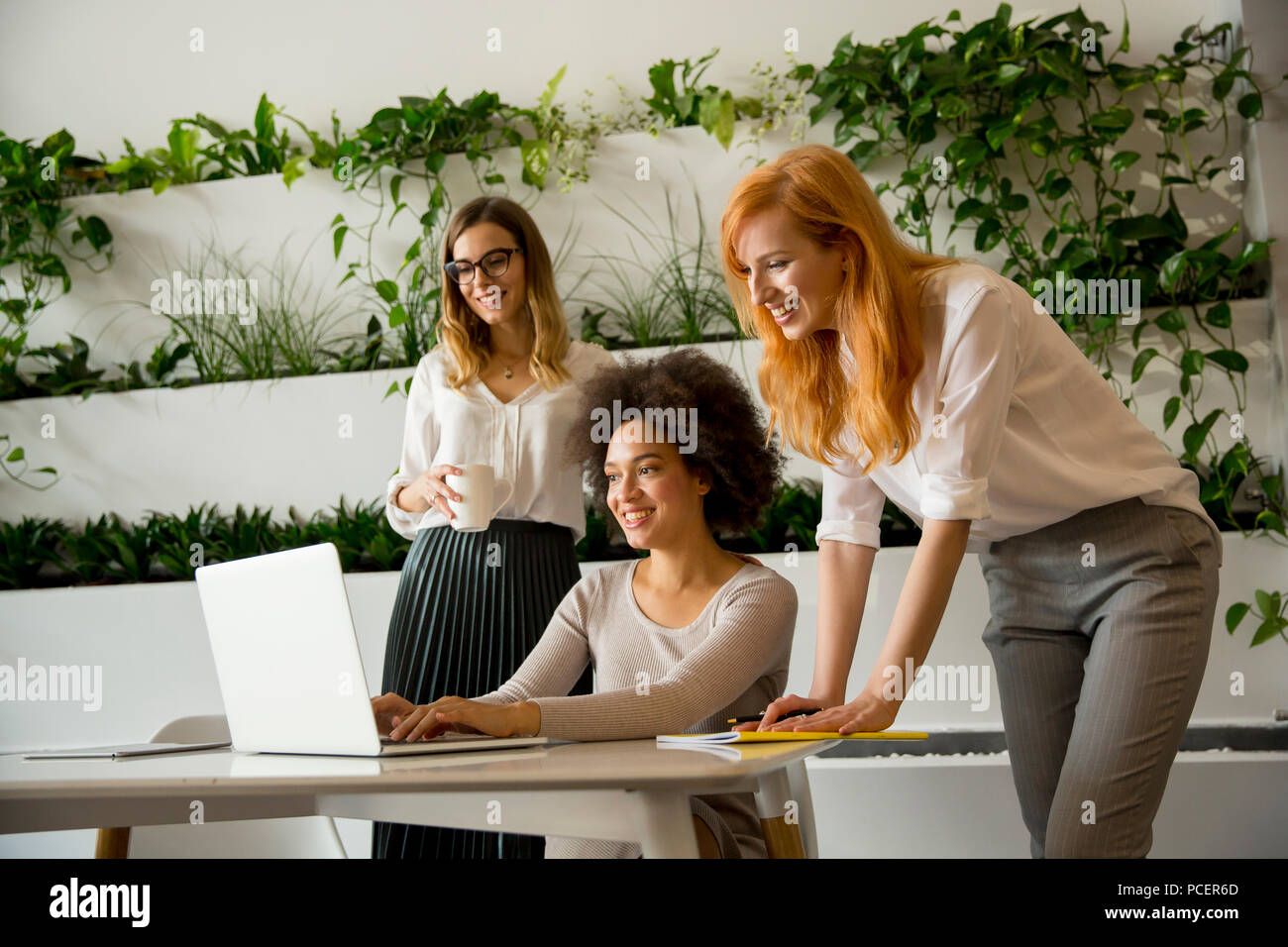 Cheerful professional multiracial women working and presenting data in ...