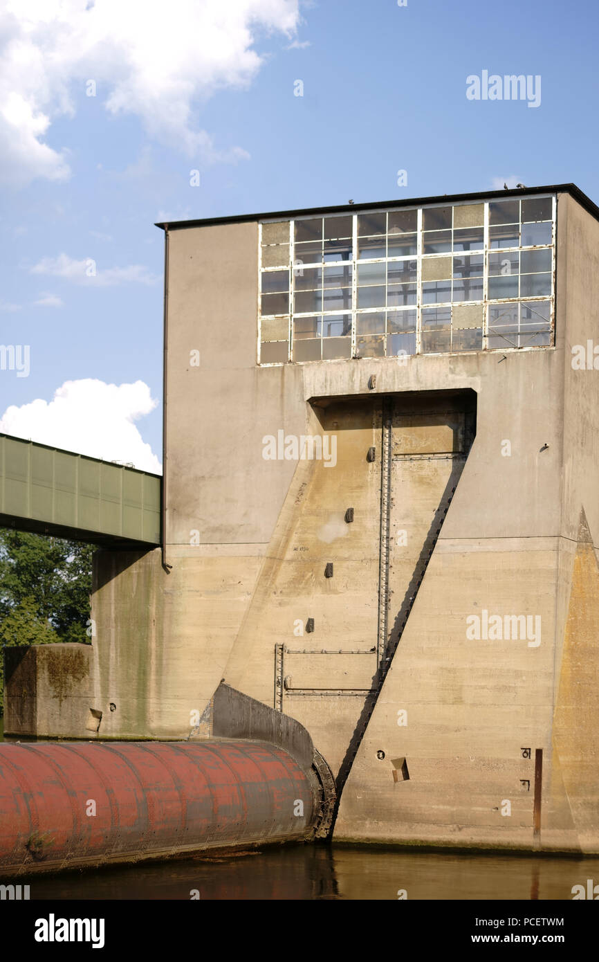 A closed river lock with dormant river water and industrial buildings ...