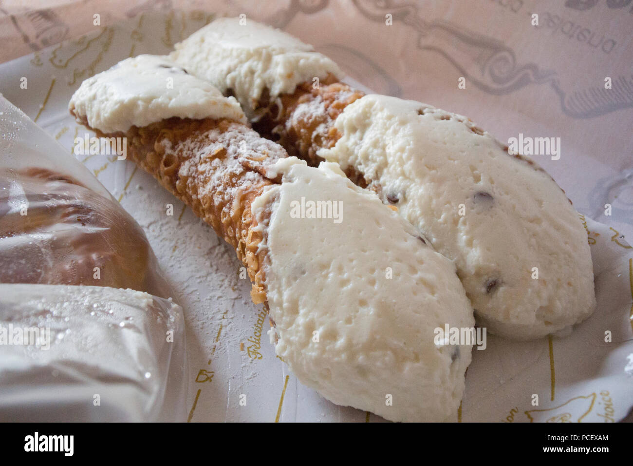 A pair of typical Sicilian cannoli, giant size, on a white wrapper ...