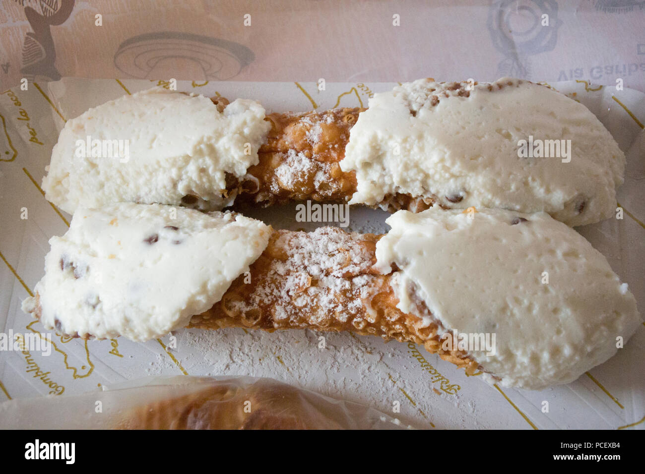 A pair of typical Sicilian cannoli, giant size, on a white wrapper ...