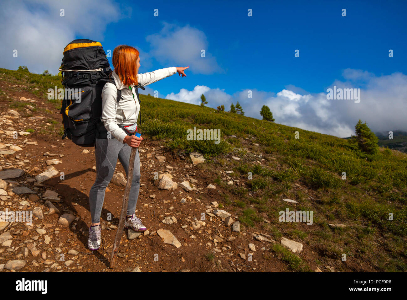 Hiking woman with backpack enjoying the trekking and showing the hand ...