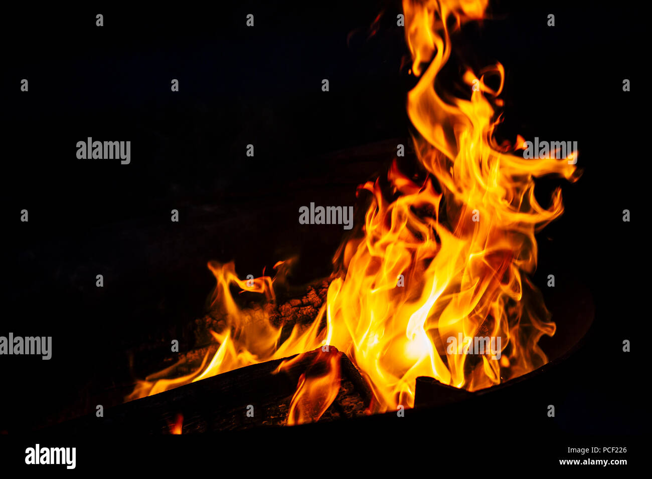 Night scene of fire sparks and flame burning with beautiful red flame ...