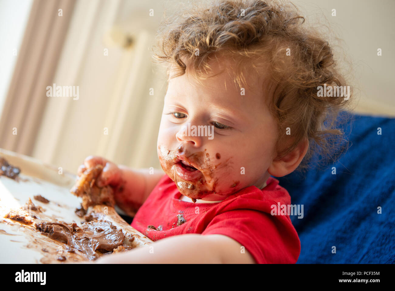 a baby is eating a chocolate cake Stock Photo - Alamy