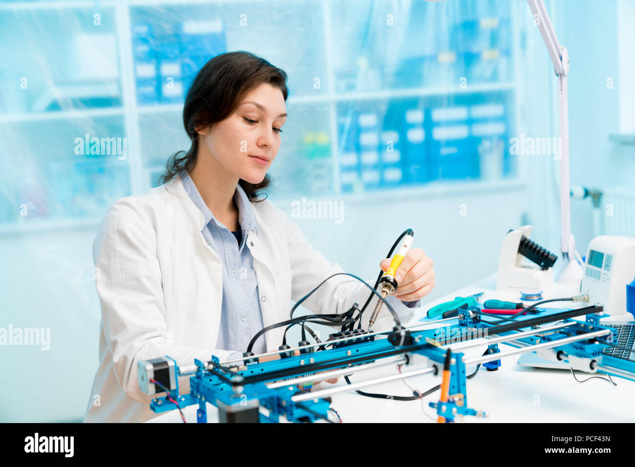 Student girl in electronics laboratory, experiment with microcontroller ...