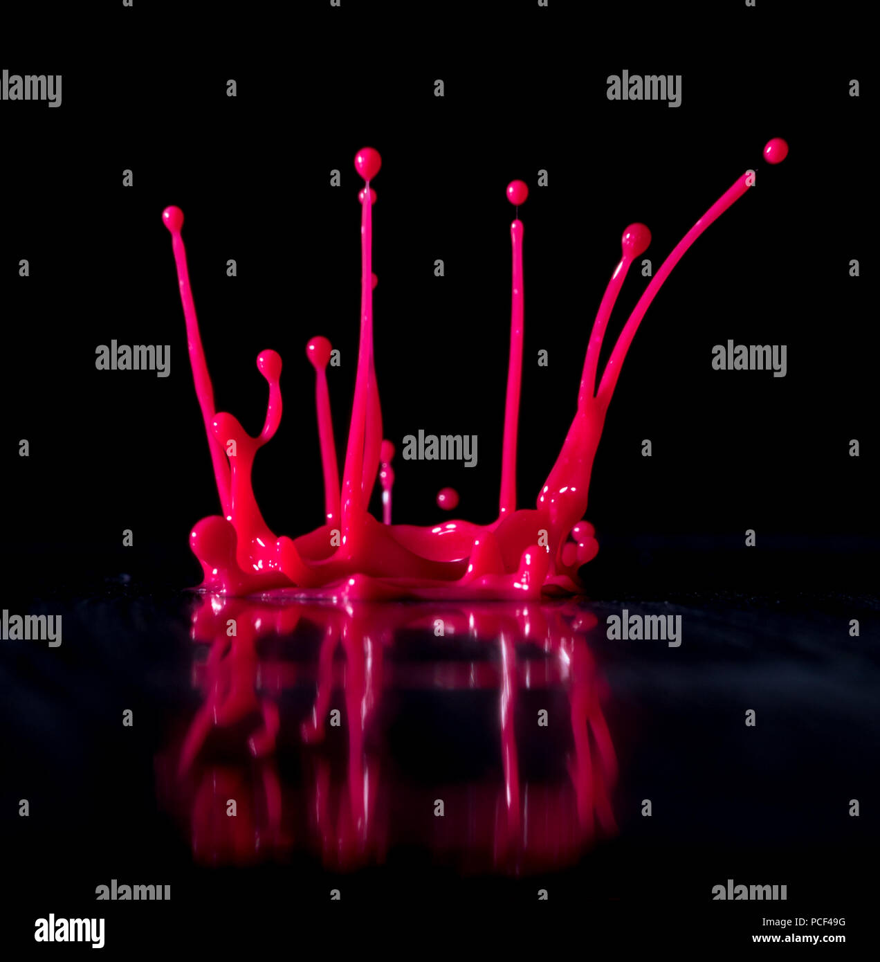 Red paint, ink splash on black background Stock Photo - Alamy