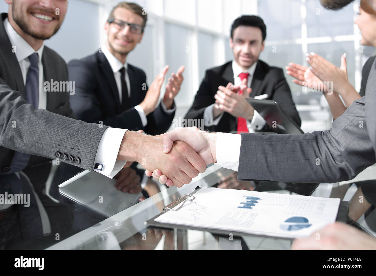 handshake business partners over the Desk Stock Photo - Alamy