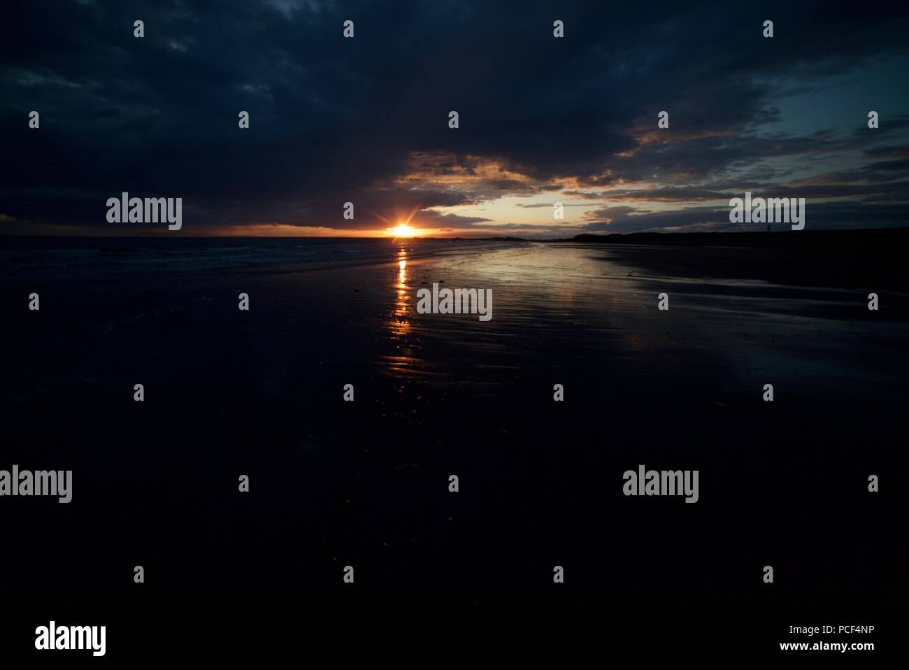 Beautiful orange sun set at a sandy beach along the Ayrshire Coast ...