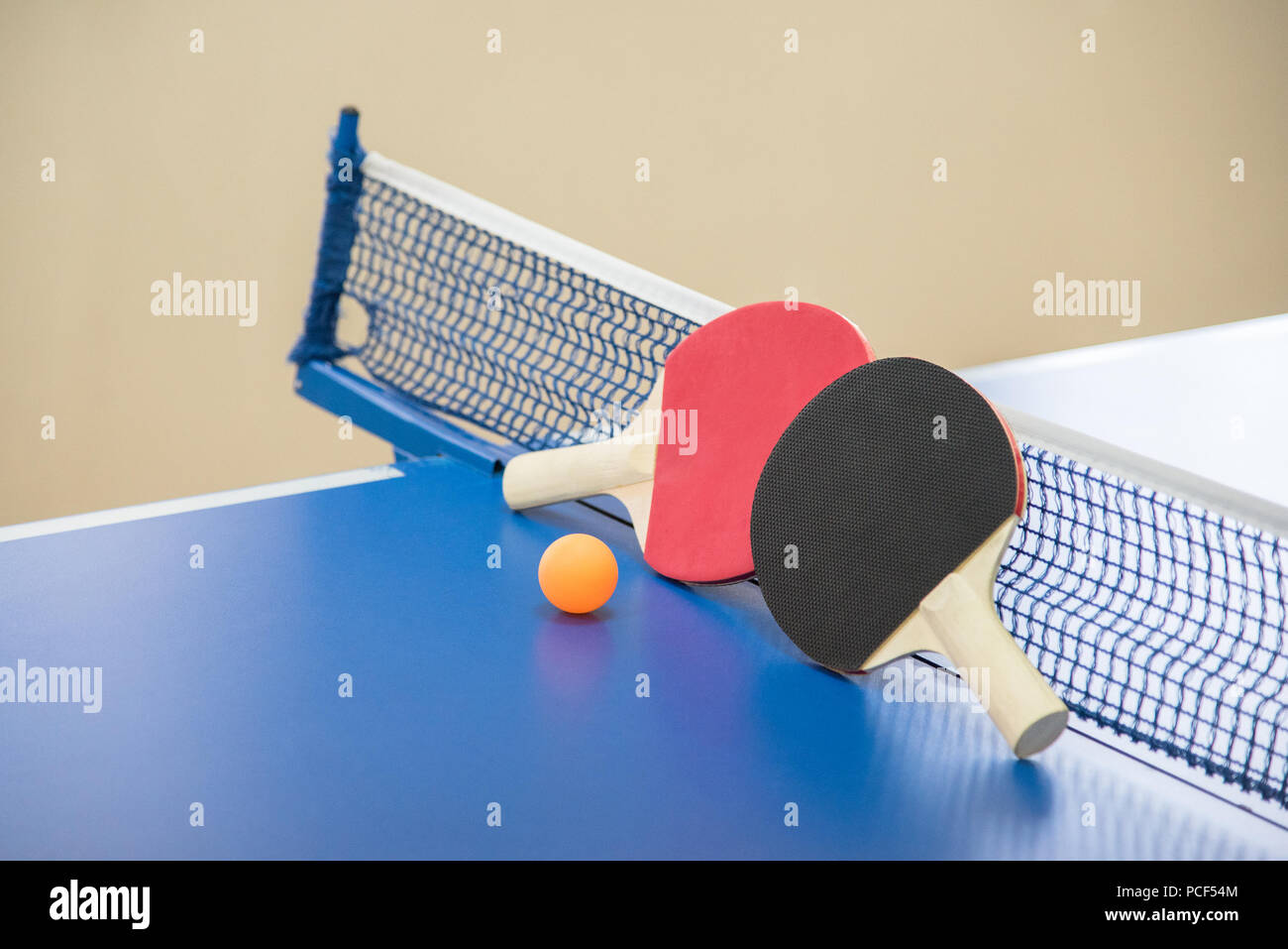Orange ball for table tennis and two wooden rackets of red and black ...
