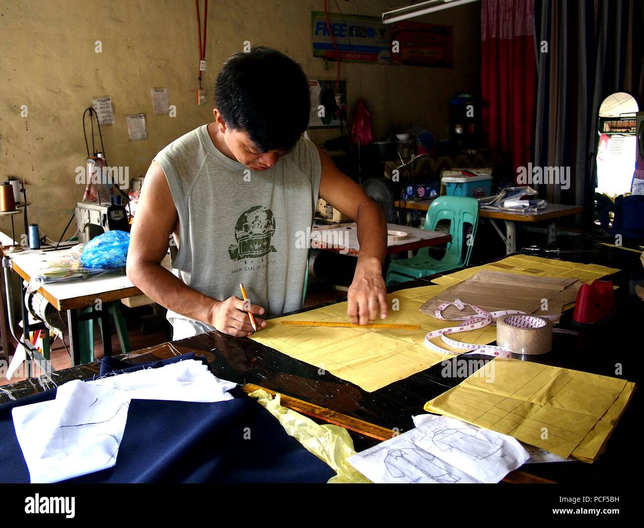 ANTIPOLO CITY, PHILIPPINES - JULY 30, 2018: A tailor creates a pattern ...