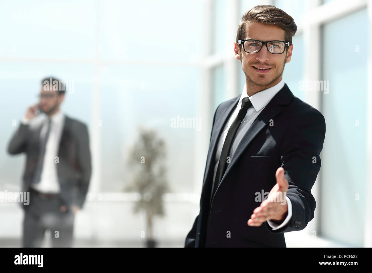 successful businessman reaching out for a handshake Stock Photo - Alamy