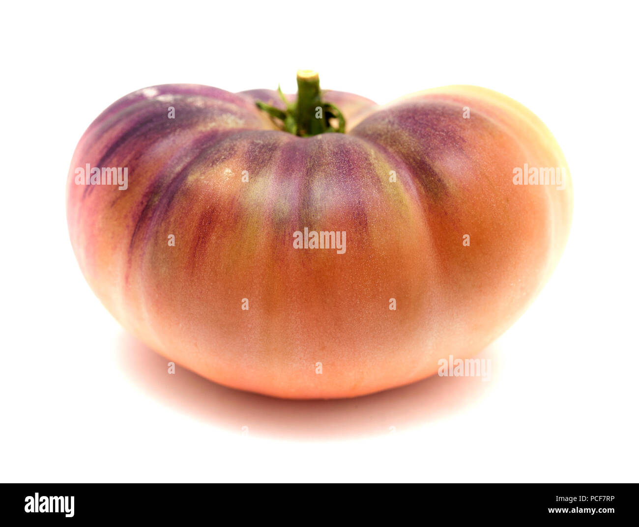 single unripe blue tomato isolated on white background Stock Photo - Alamy