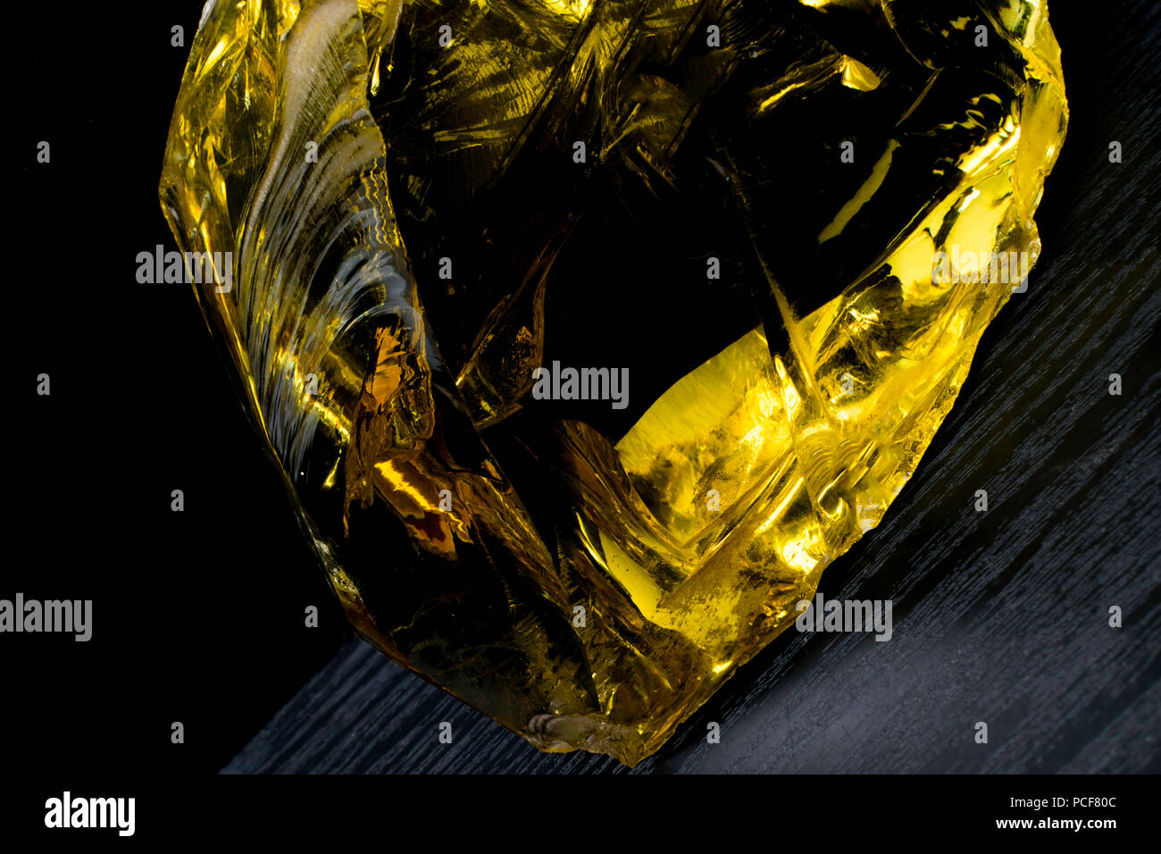 Beautiful big piece of amber heart on a black background. Sun stone ...