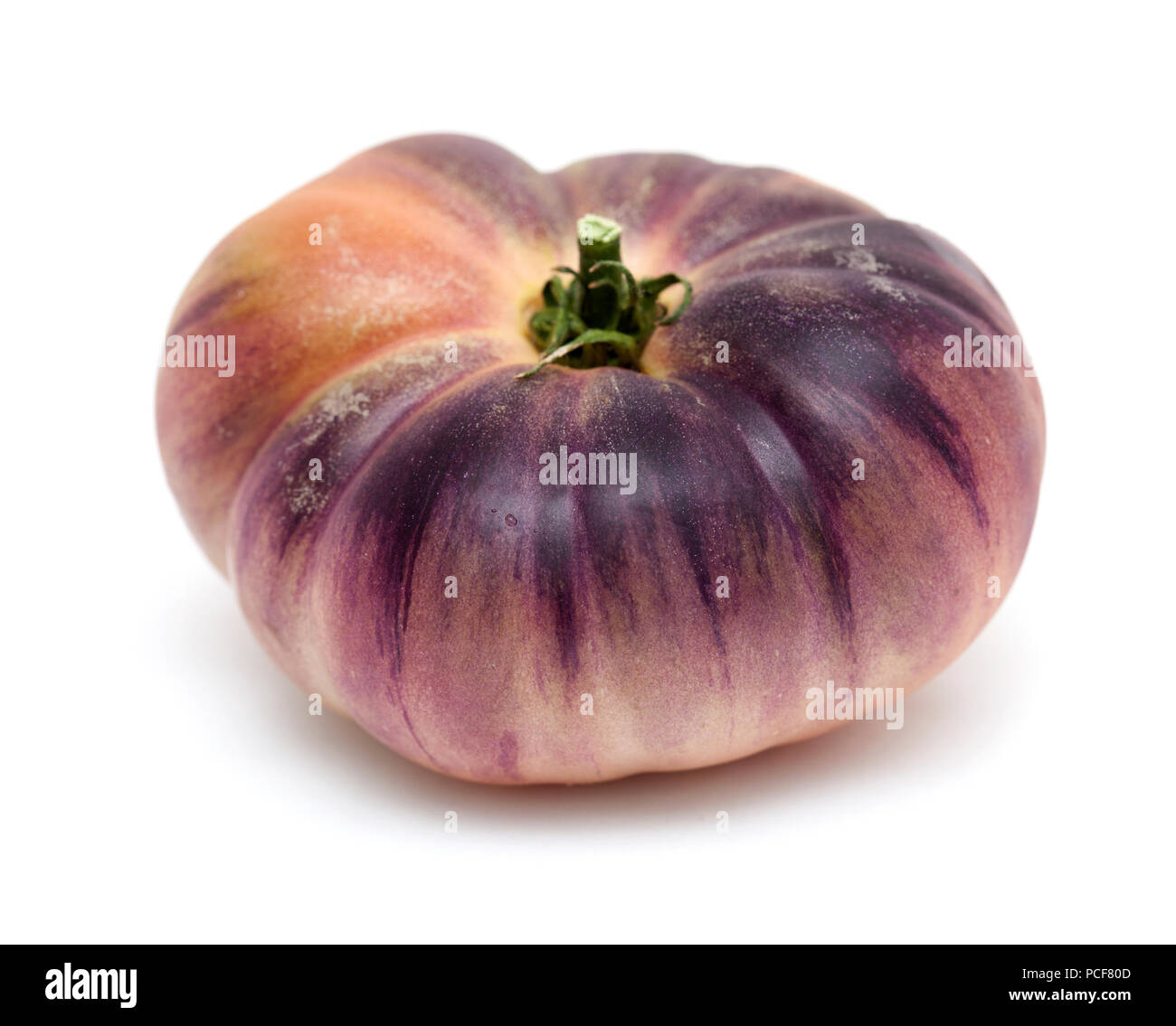 single unripe blue tomato isolated on white background Stock Photo - Alamy
