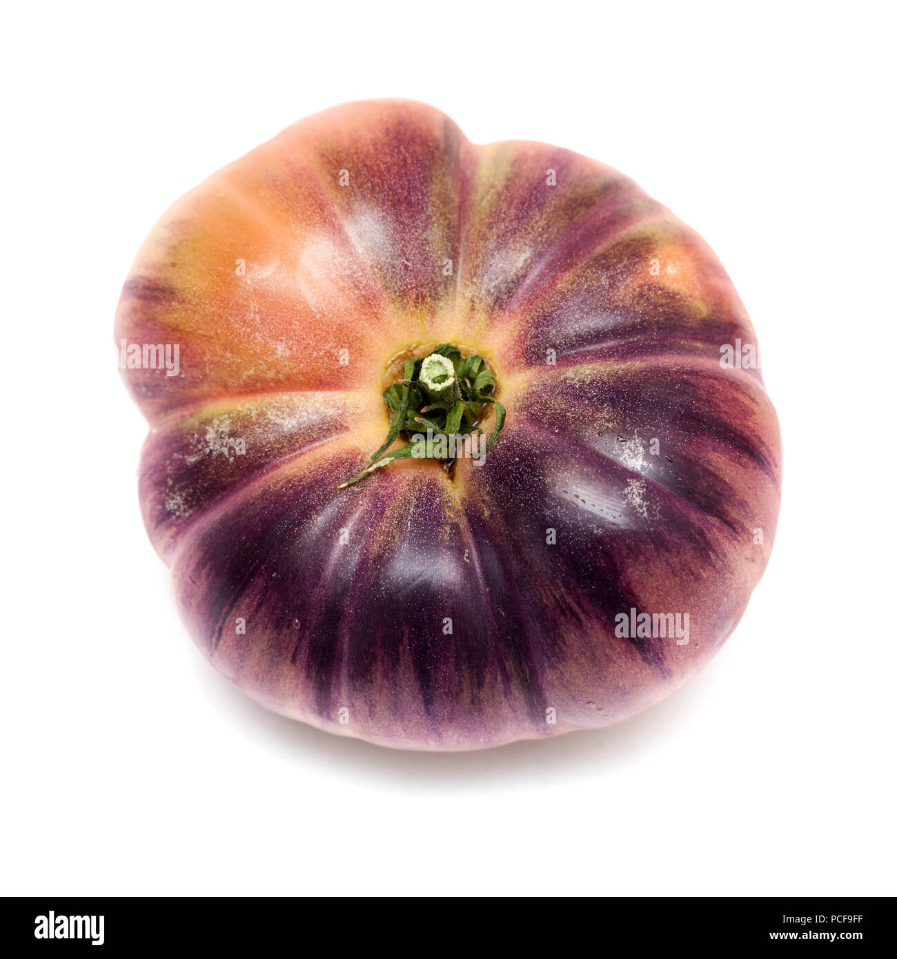 single unripe blue tomato isolated on white background Stock Photo - Alamy