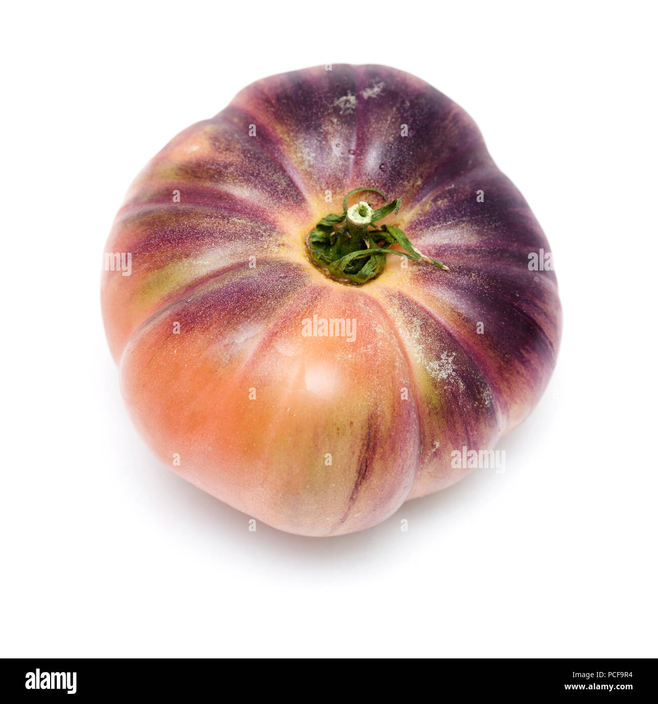 single unripe blue tomato isolated on white background Stock Photo - Alamy